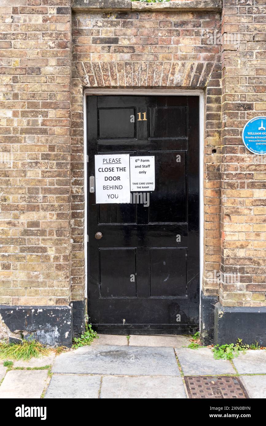 Black door with please close door behind you notice Stock Photo - Alamy