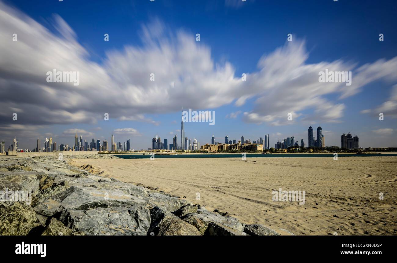 Fast-moving clouds over Dubai skyline on a bright day, showcasing the ...