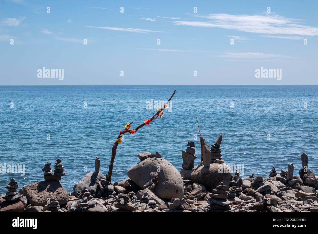 Stone towers made of beach pebbles. Coast of the Atlantic ocen. Blue ...