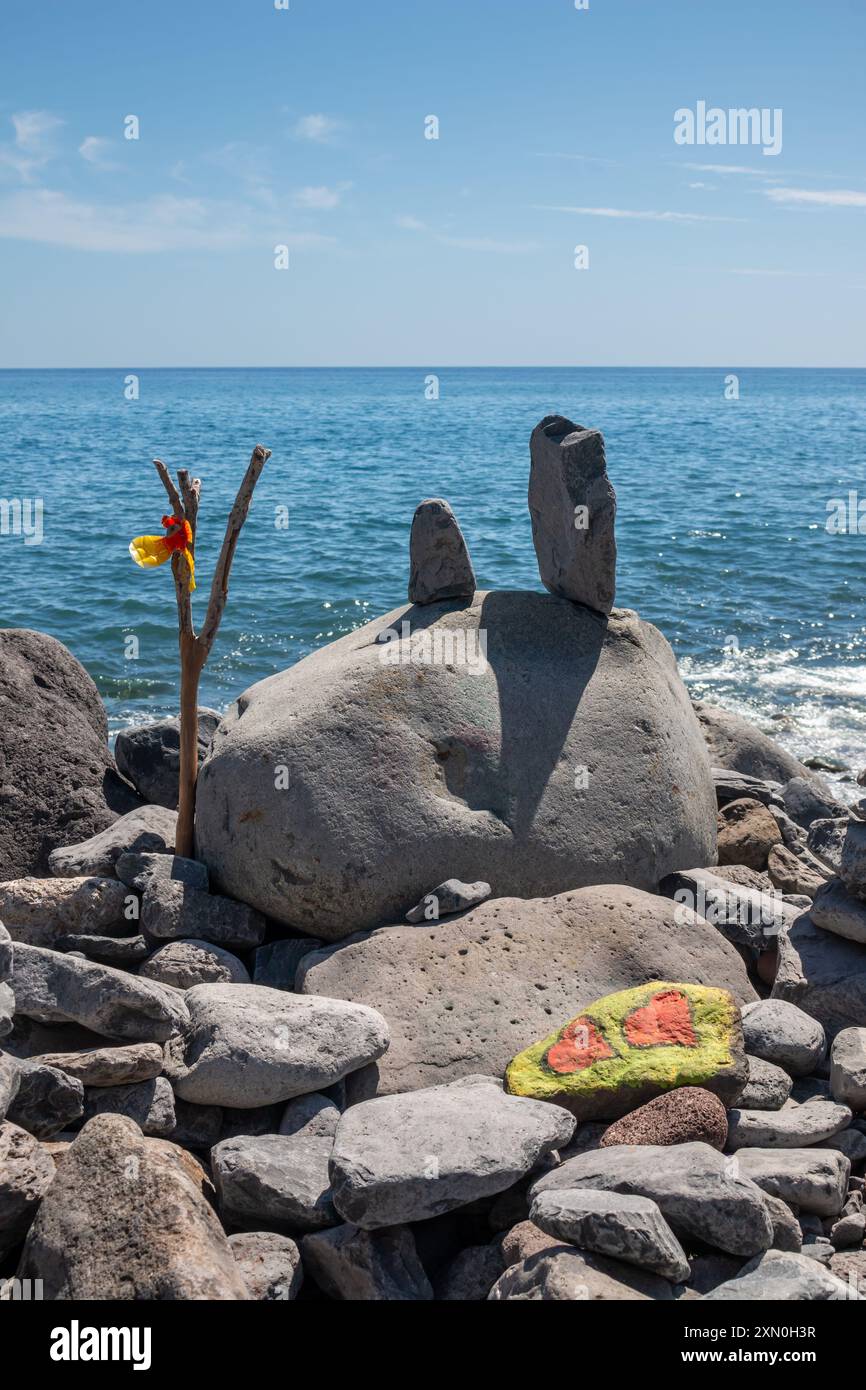 Stone towers made of beach pebbles. Coast of the Atlantic ocen. Blue ...