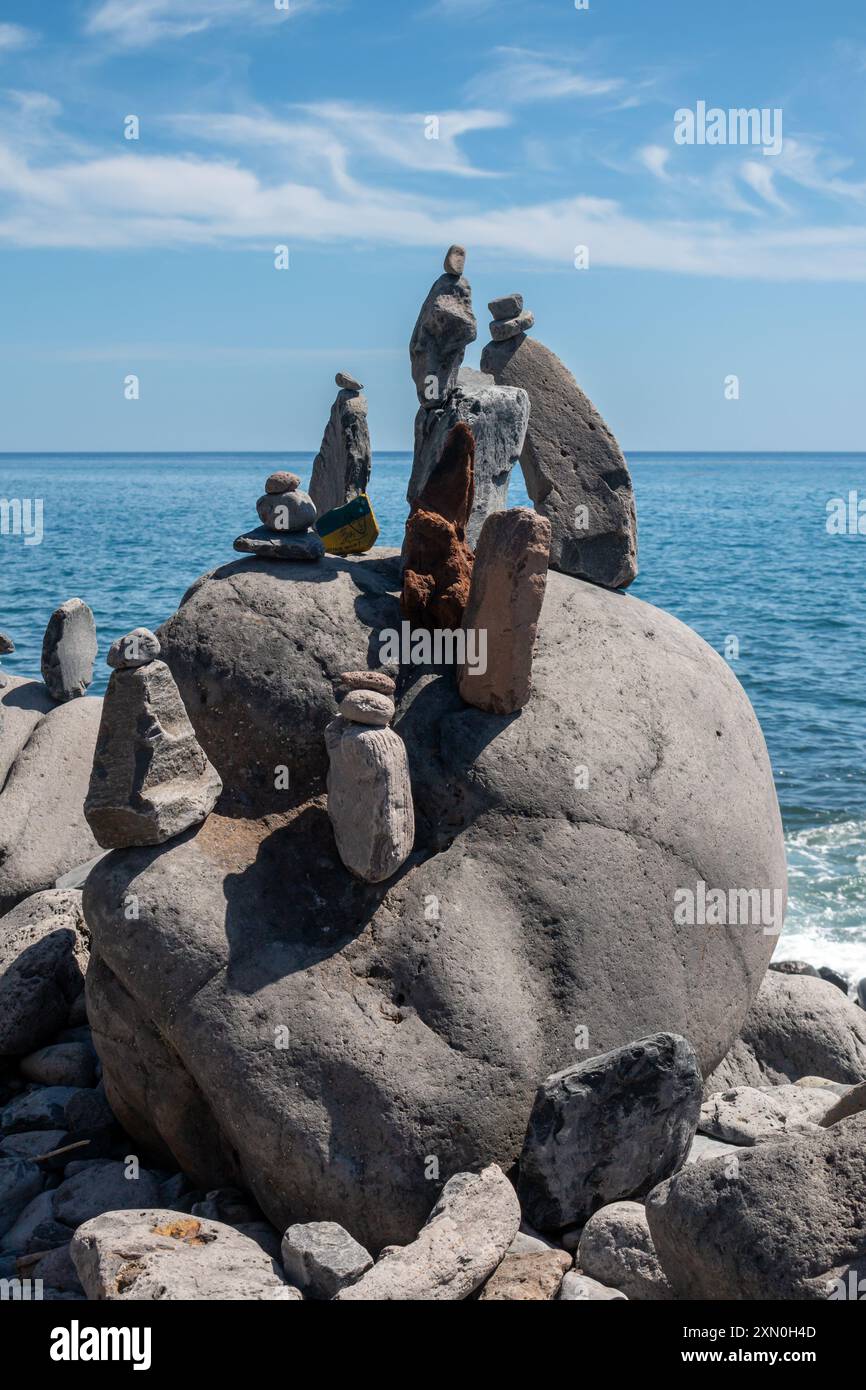 Stone towers made of beach pebbles. Coast of the Atlantic ocen. Blue ...