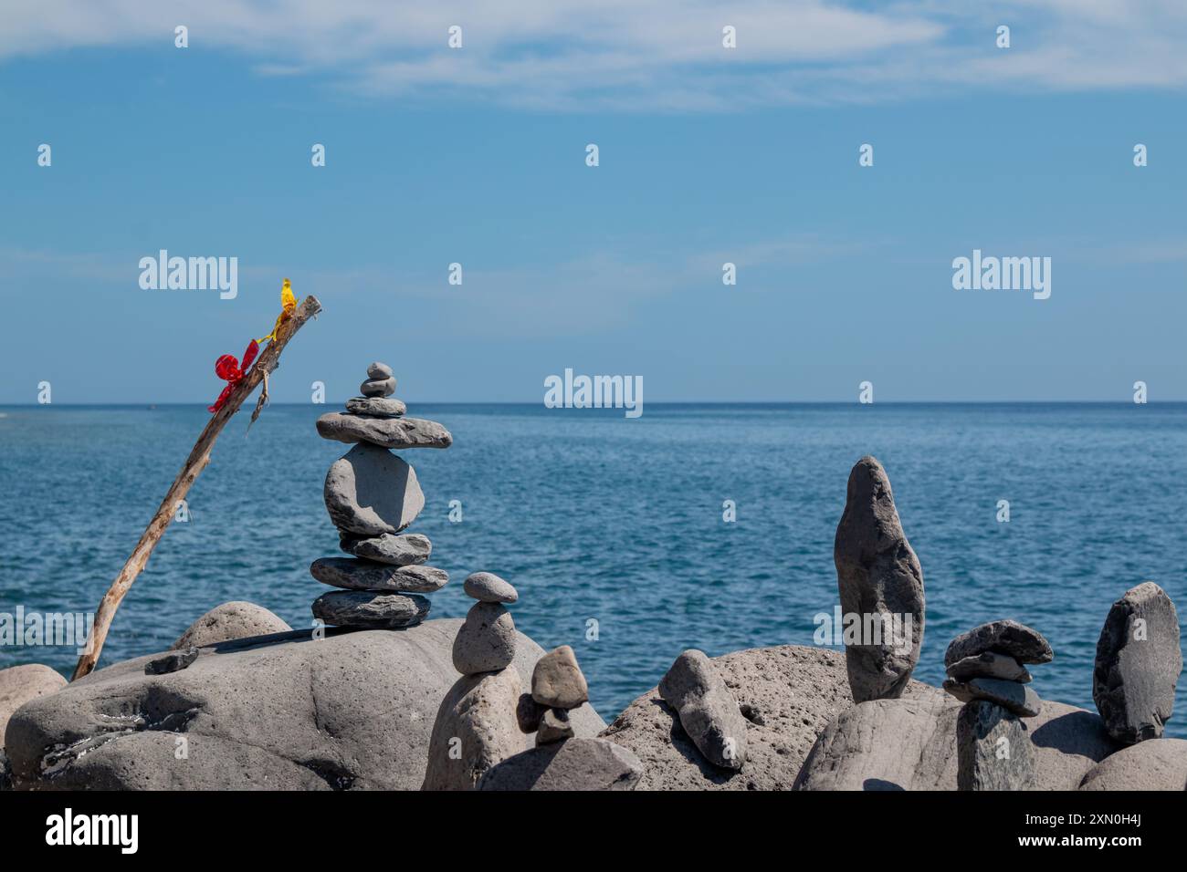 Stone towers made of beach pebbles. Coast of the Atlantic ocen. Blue ...