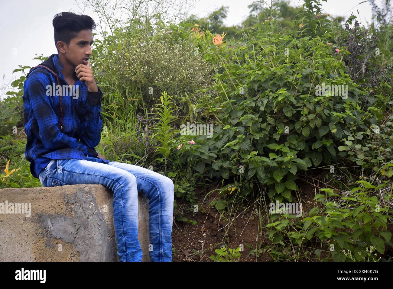 Indian model boy in blue dress posing, outdoor greenery background ...