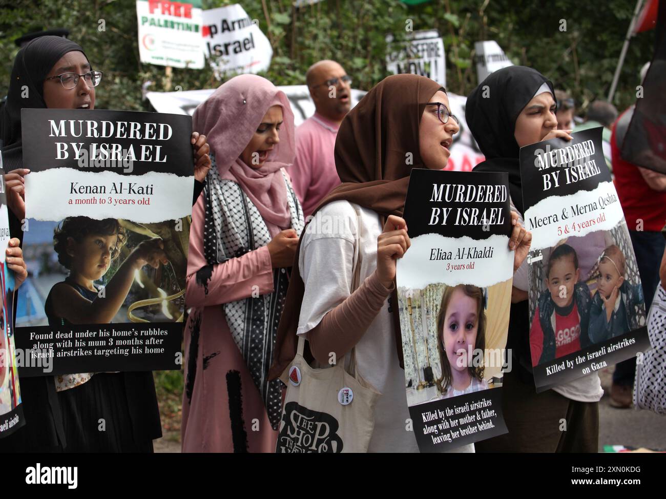 July 30, 2024, Shenstone, England, UK: Protesters hold up signs with ...