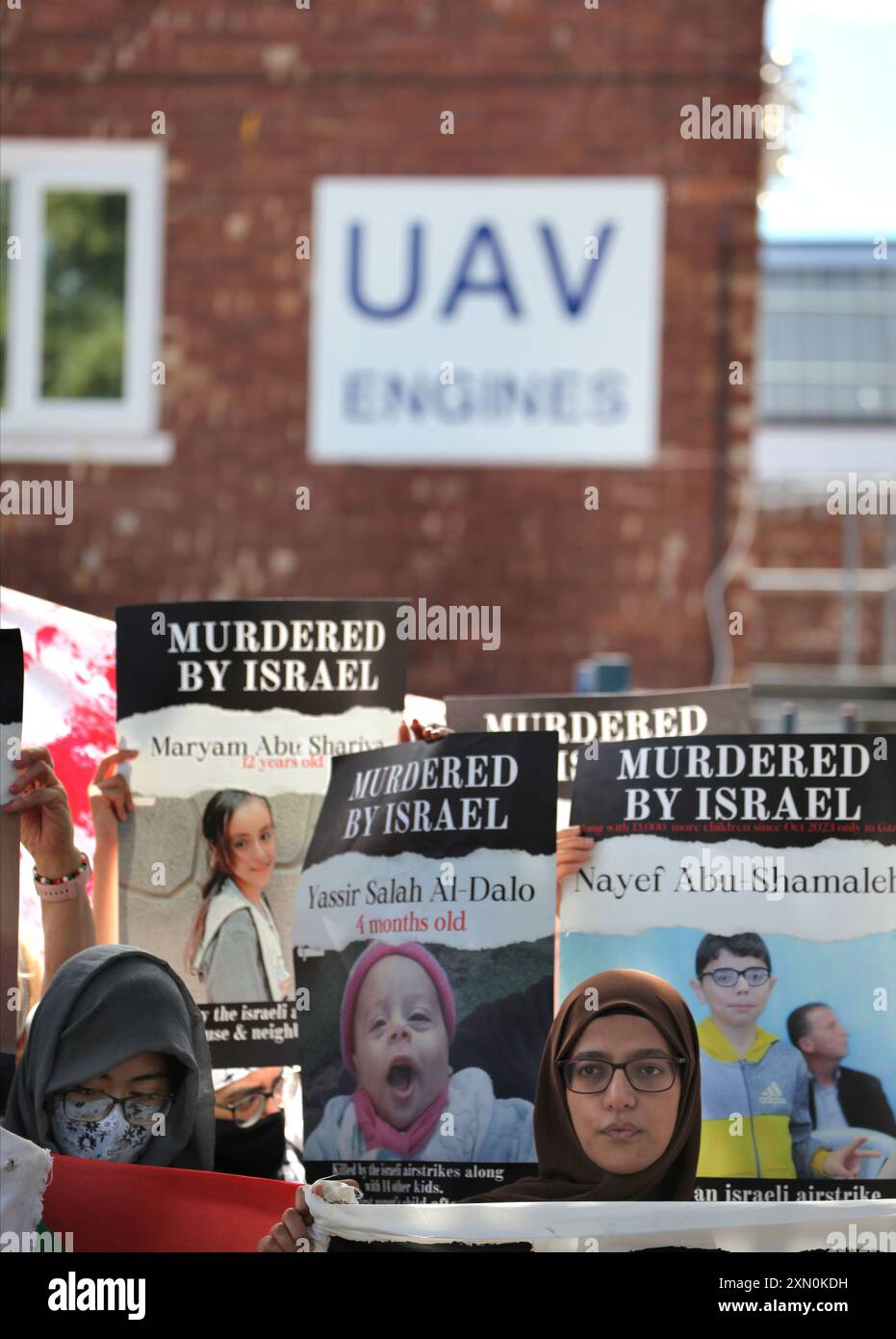 July 30, 2024, Shenstone, England, UK: Protesters hold up signs with ...
