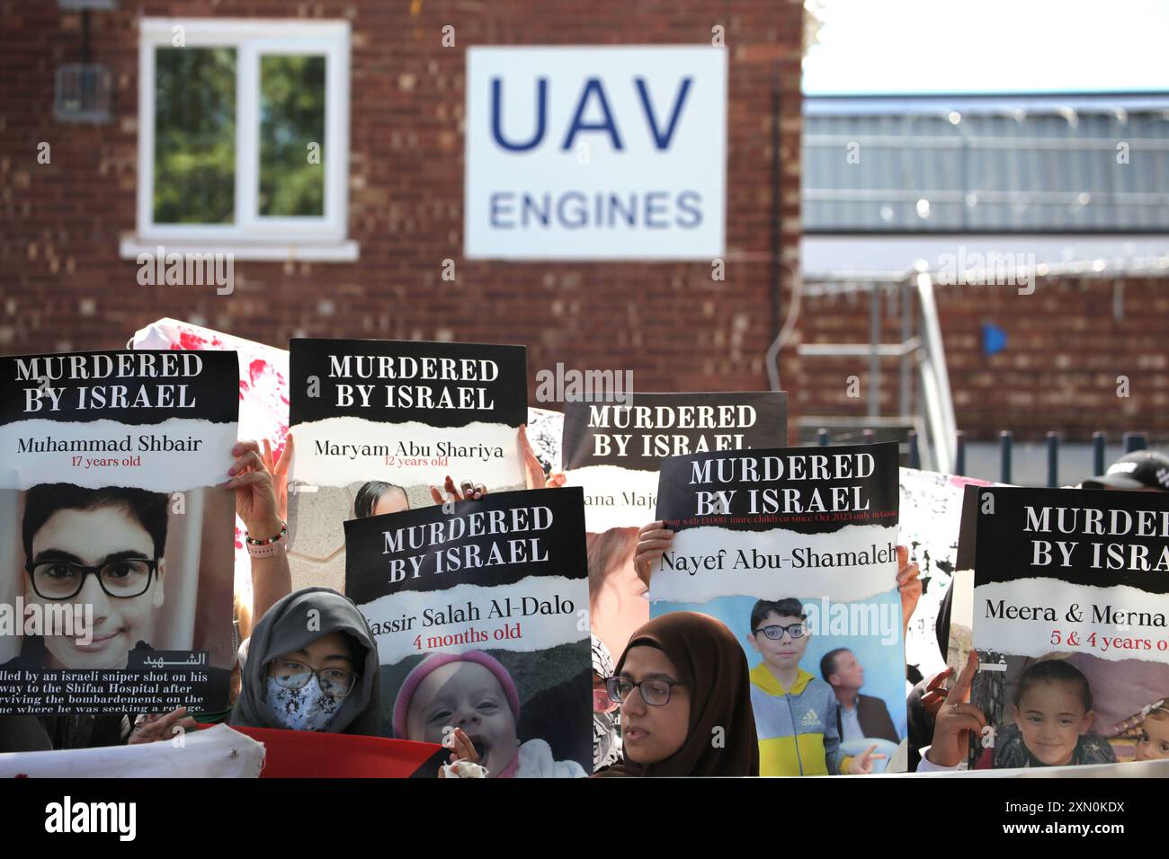 July 30, 2024, Shenstone, England, UK: Protesters hold up signs with ...