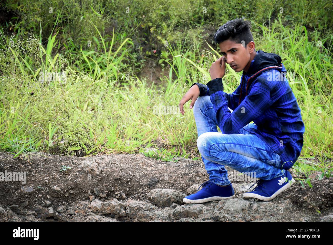 Indian model boy in blue dress posing, outdoor greenery background ...