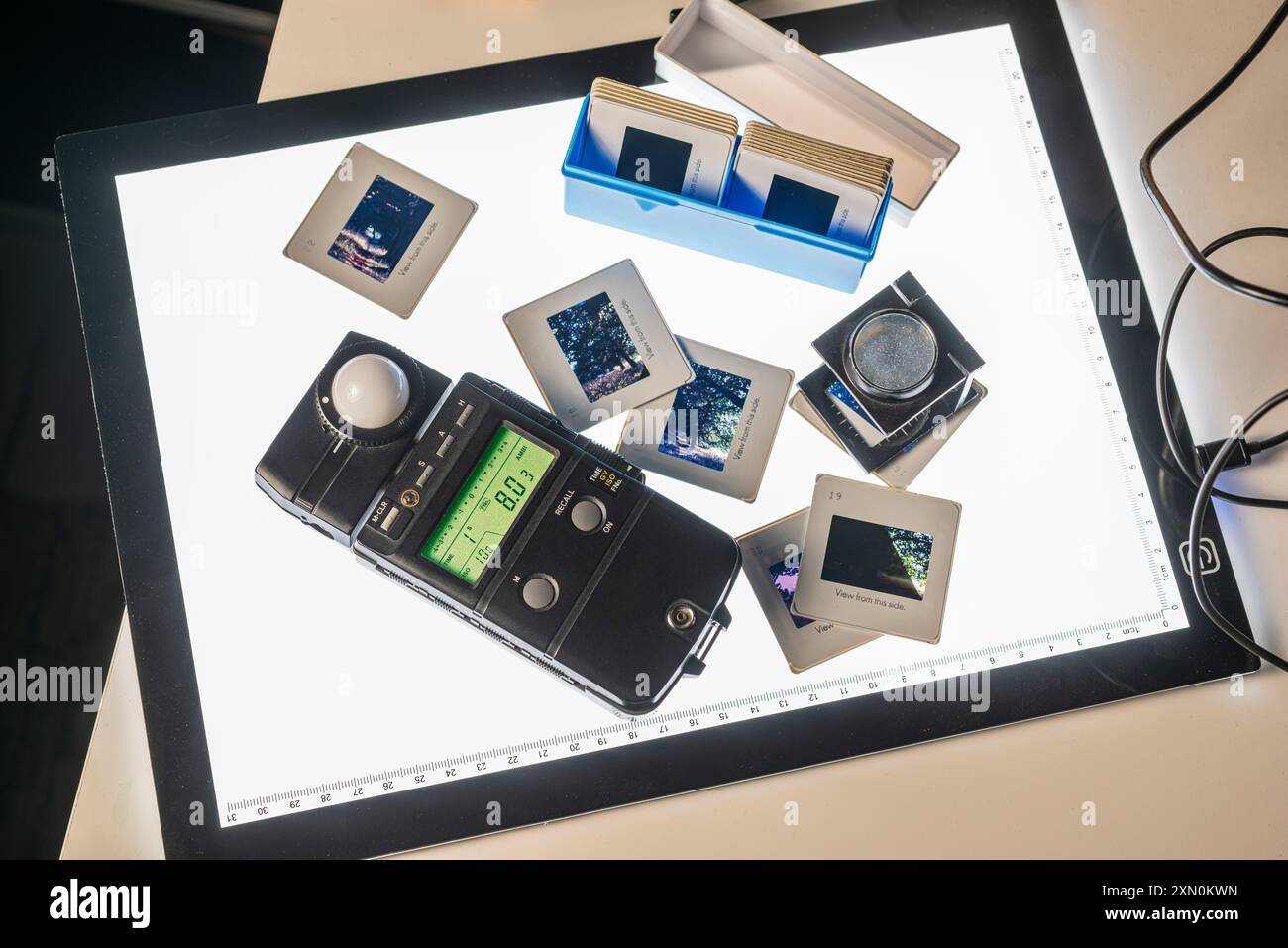 Lightmeter and 35mm transparency slides on a Lightbox in a photographic ...