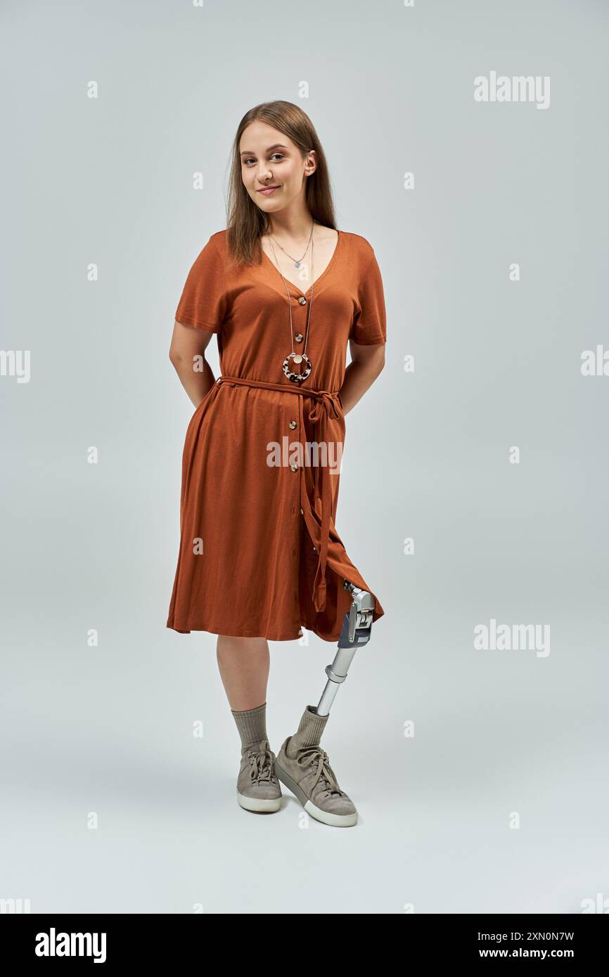Woman confidently showing off prosthetic leg in brown dress, sneakers ...