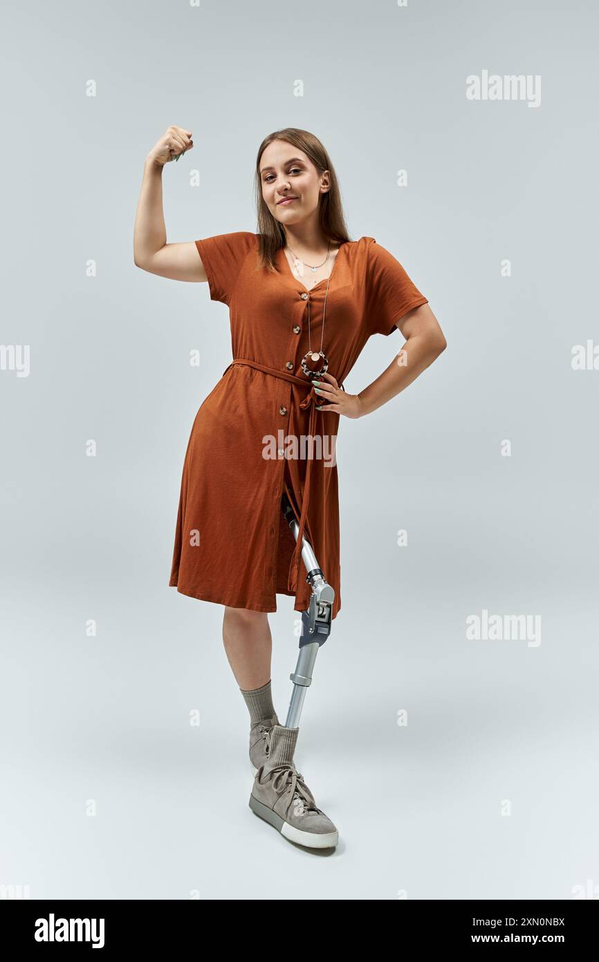 A woman in a brown dress stands with her arm raised, confidently ...