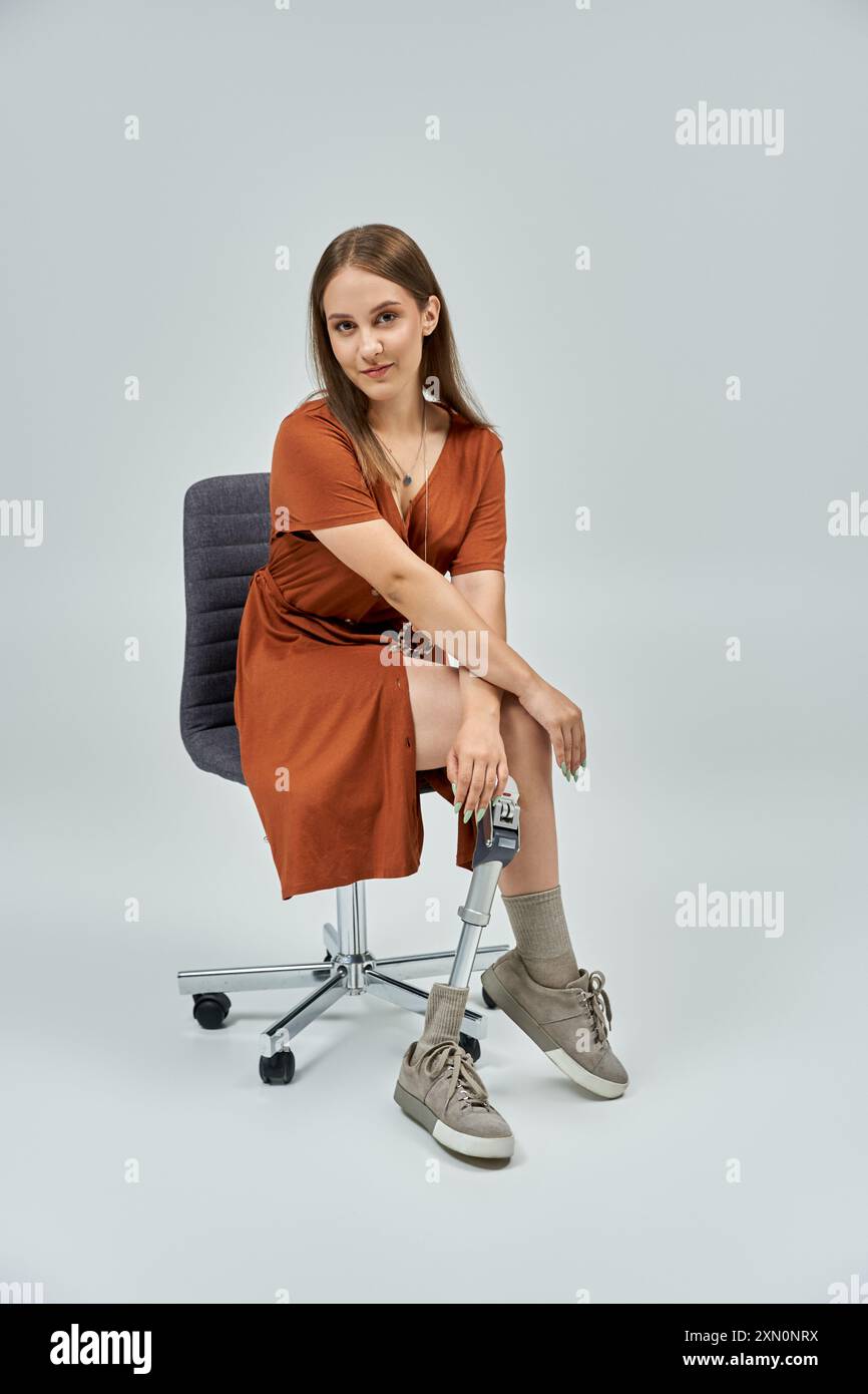A woman sits on a chair, confidently looking at the camera with her ...