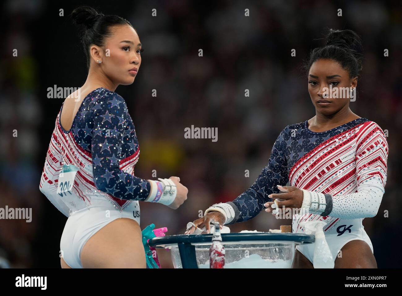 Simone Biles, and Suni Lee, left, of the United States, prepare to ...