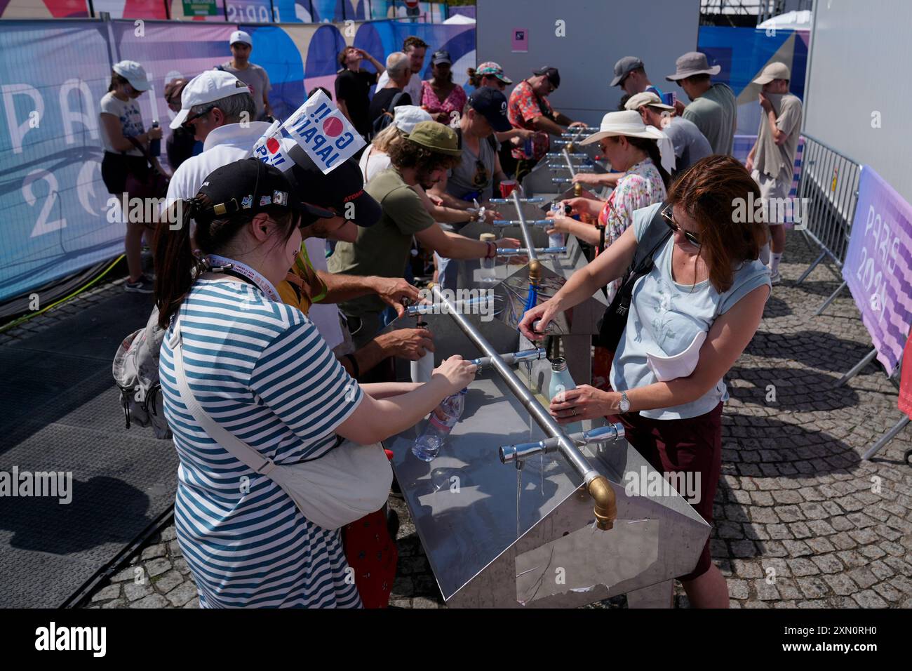 Fans fill their water bottles on a hot afternoon by the cycling BMX ...