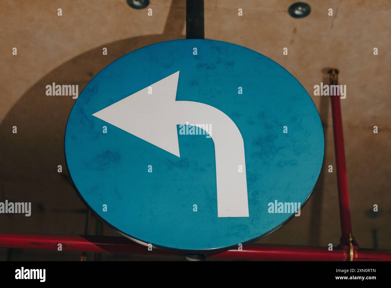 Mandatory left sign in a underground parking garage Stock Photo - Alamy