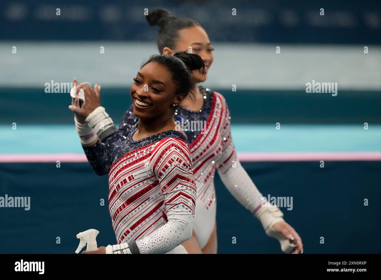 Simone Biles, of the United States, high-fives teammate Suni Lee, rear ...
