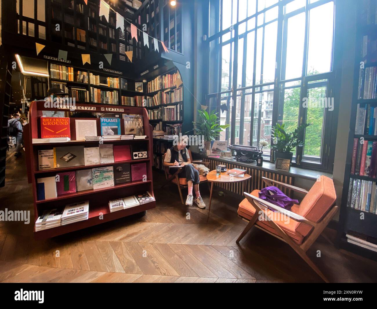 St. Petersburg, Russia, August 2021: Modern cozy bookstore. Young woman ...