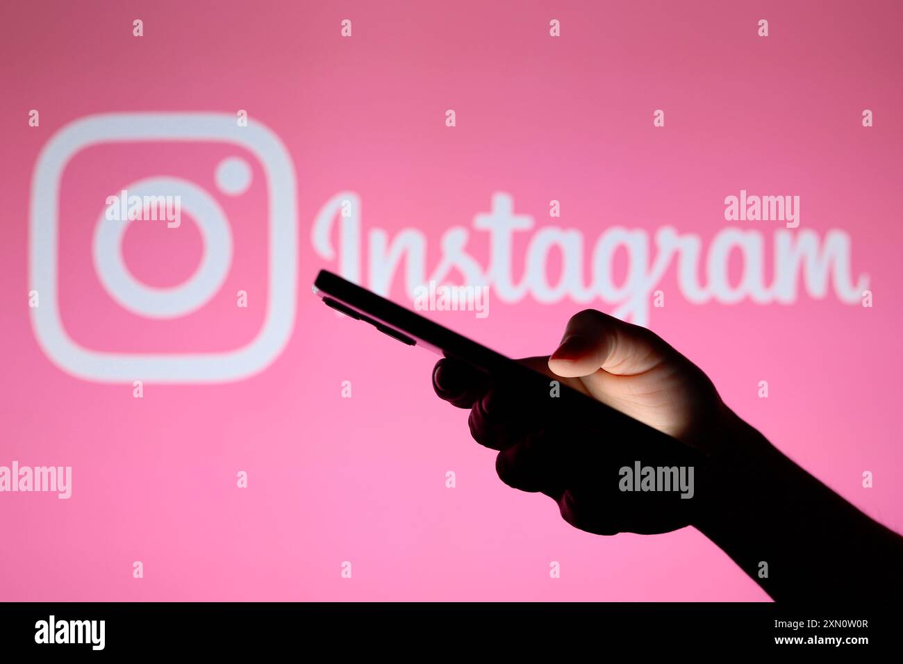 In this photo illustration, the Instagram logo seen in the background ...