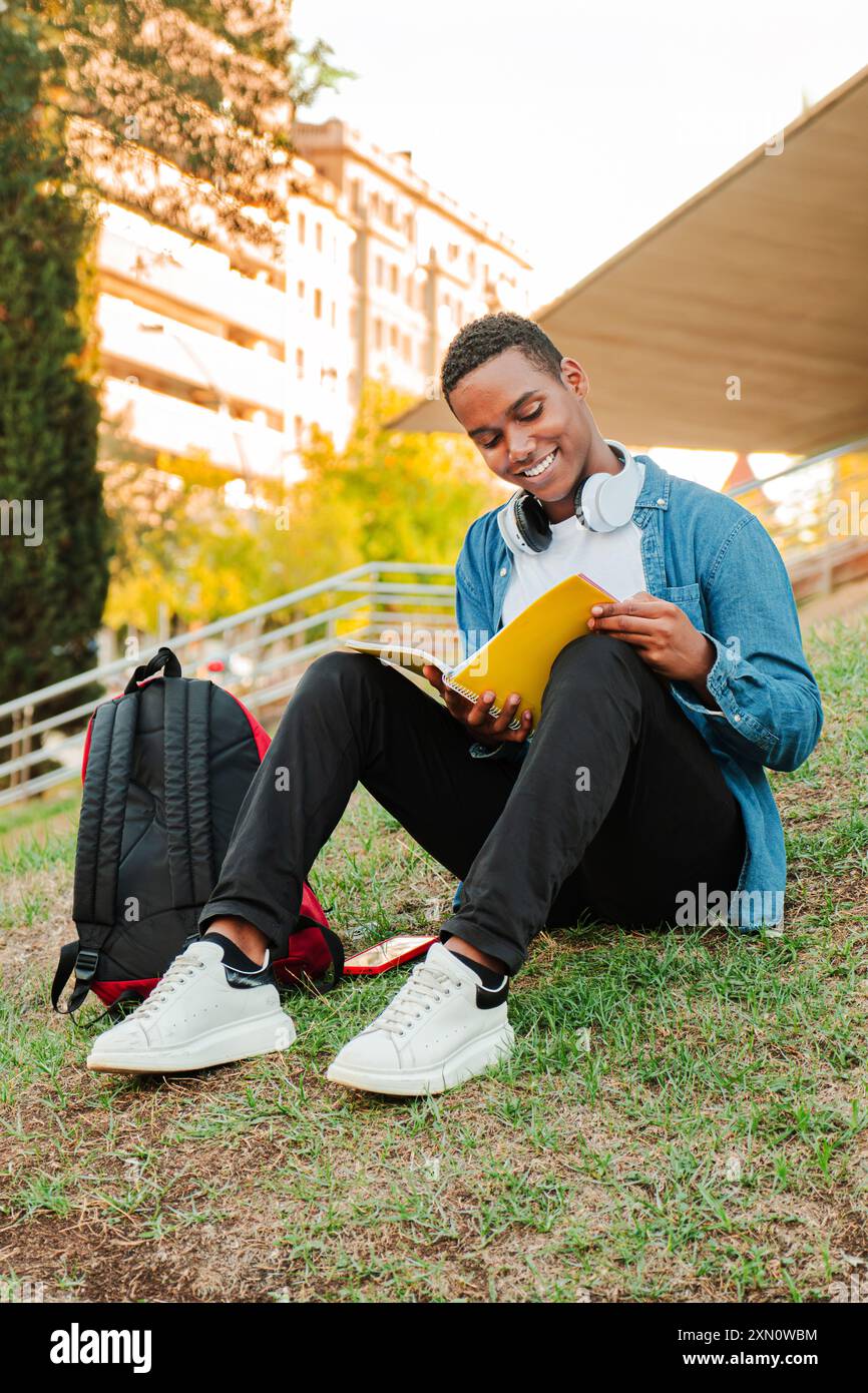Vertical. African american handsome guy reading a note book to prepare ...