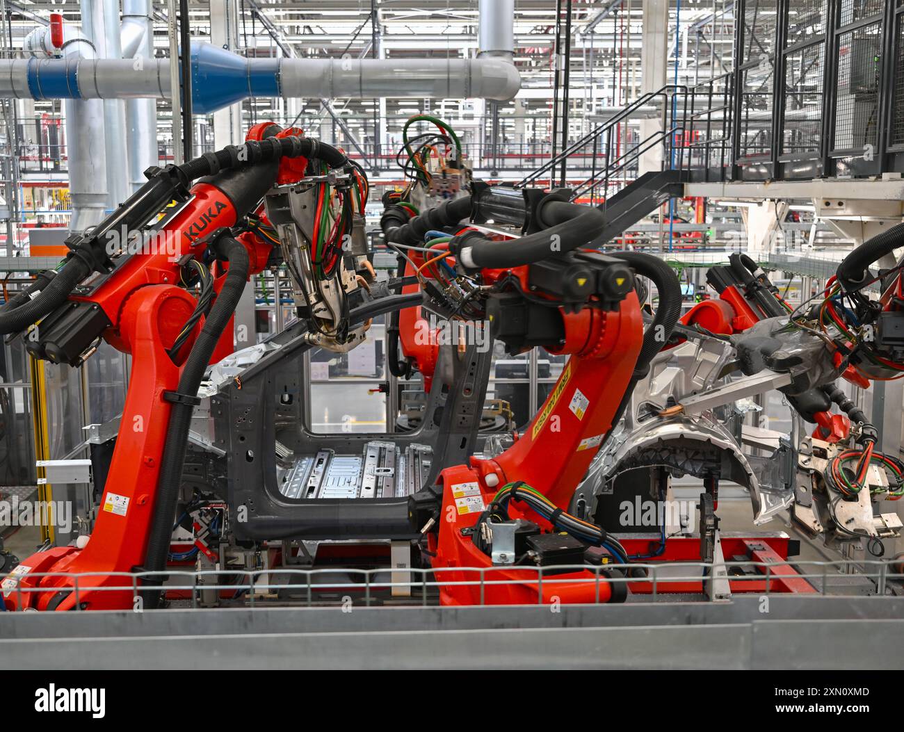 PRODUCTION - 29 July 2024, Brandenburg, Grünheide: Welding robots work ...