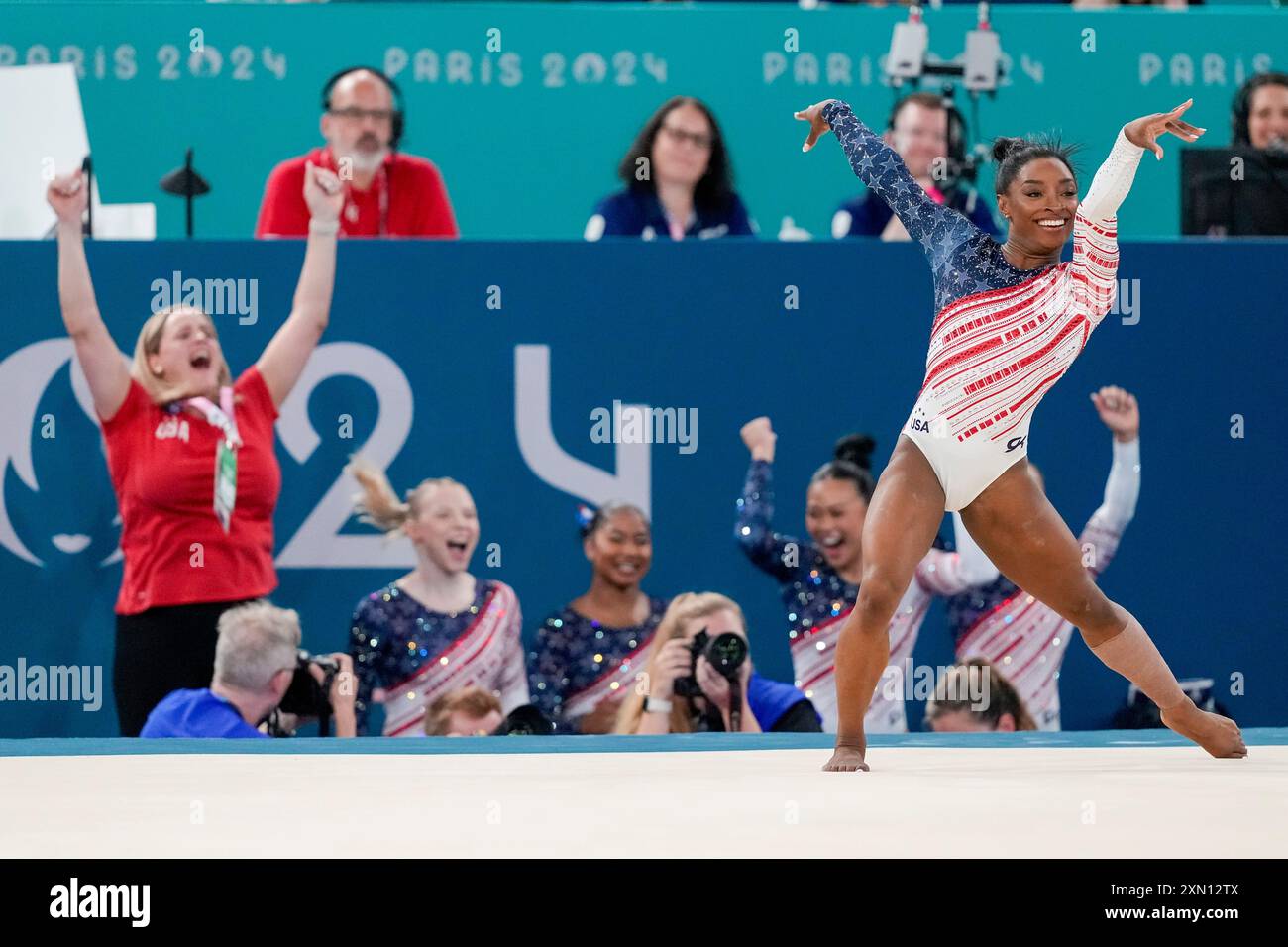 Simone Biles, of the United States, ends her floor routine as the rest ...