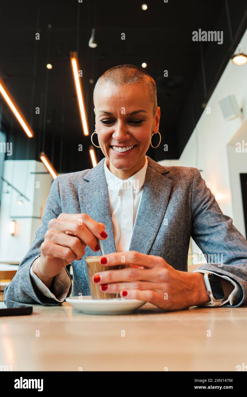 Vertical. Confident mature female drinking a coffee cup on a restaurant ...