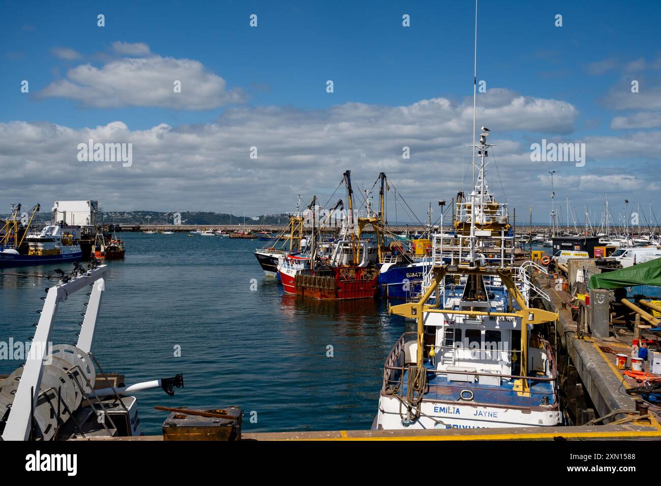 Trawlers and fishing boats moored up in the harbour in the seaside town ...