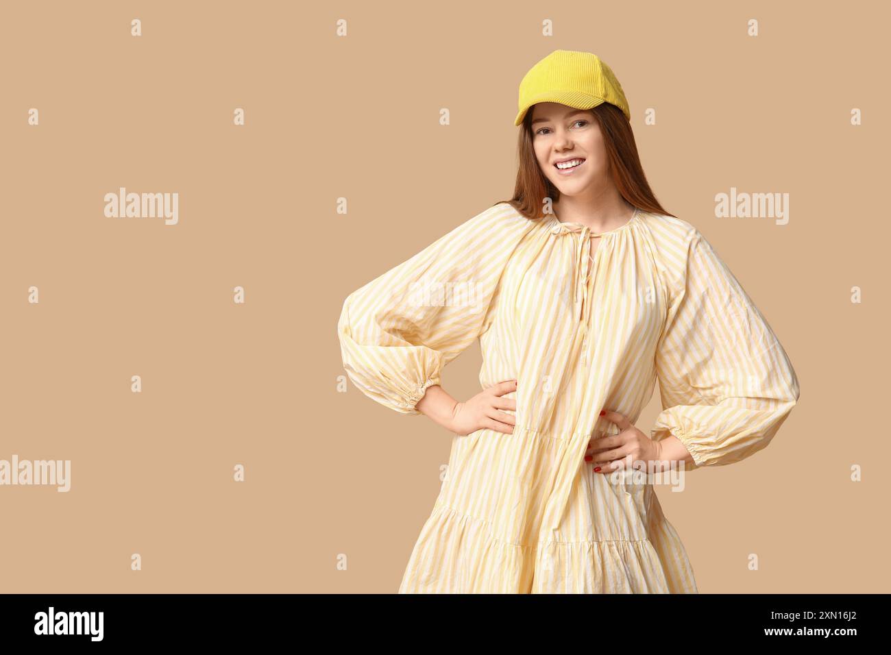 Stylish young girl in baseball cap and dress on beige background Stock ...