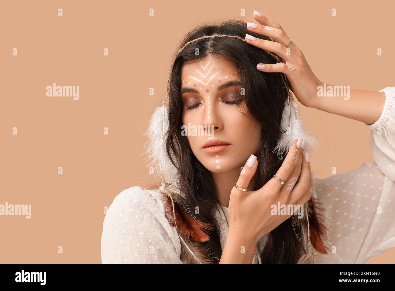 Beautiful female shaman on beige background Stock Photo - Alamy