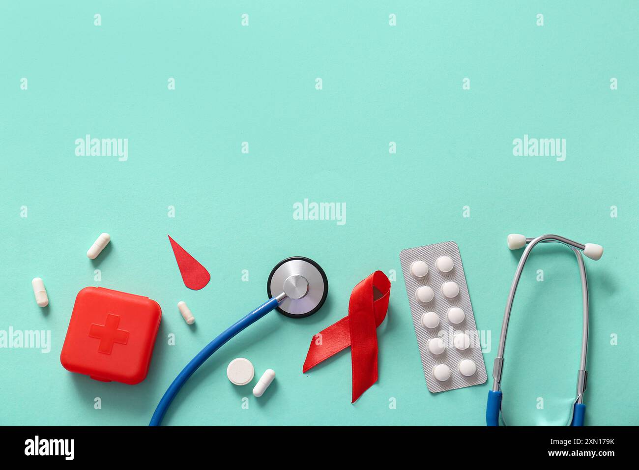 Red ribbon with stethoscope and pills on turquoise background. Blood ...
