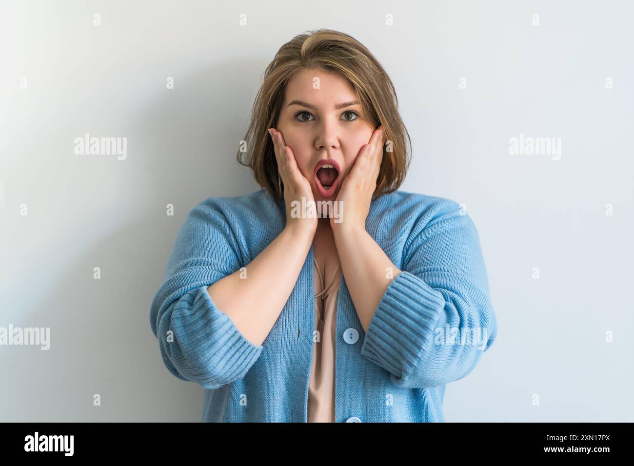 Plus size woman expression of surprise at white plain background Stock ...