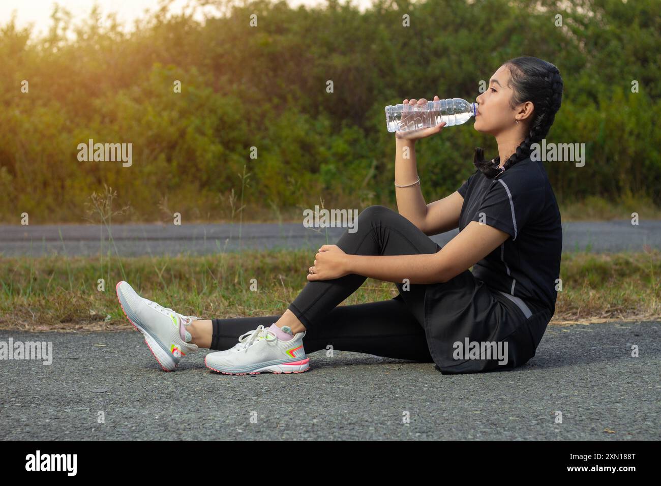 Beautiful Asian woman sitting sideways in new shoes and sportswear ...