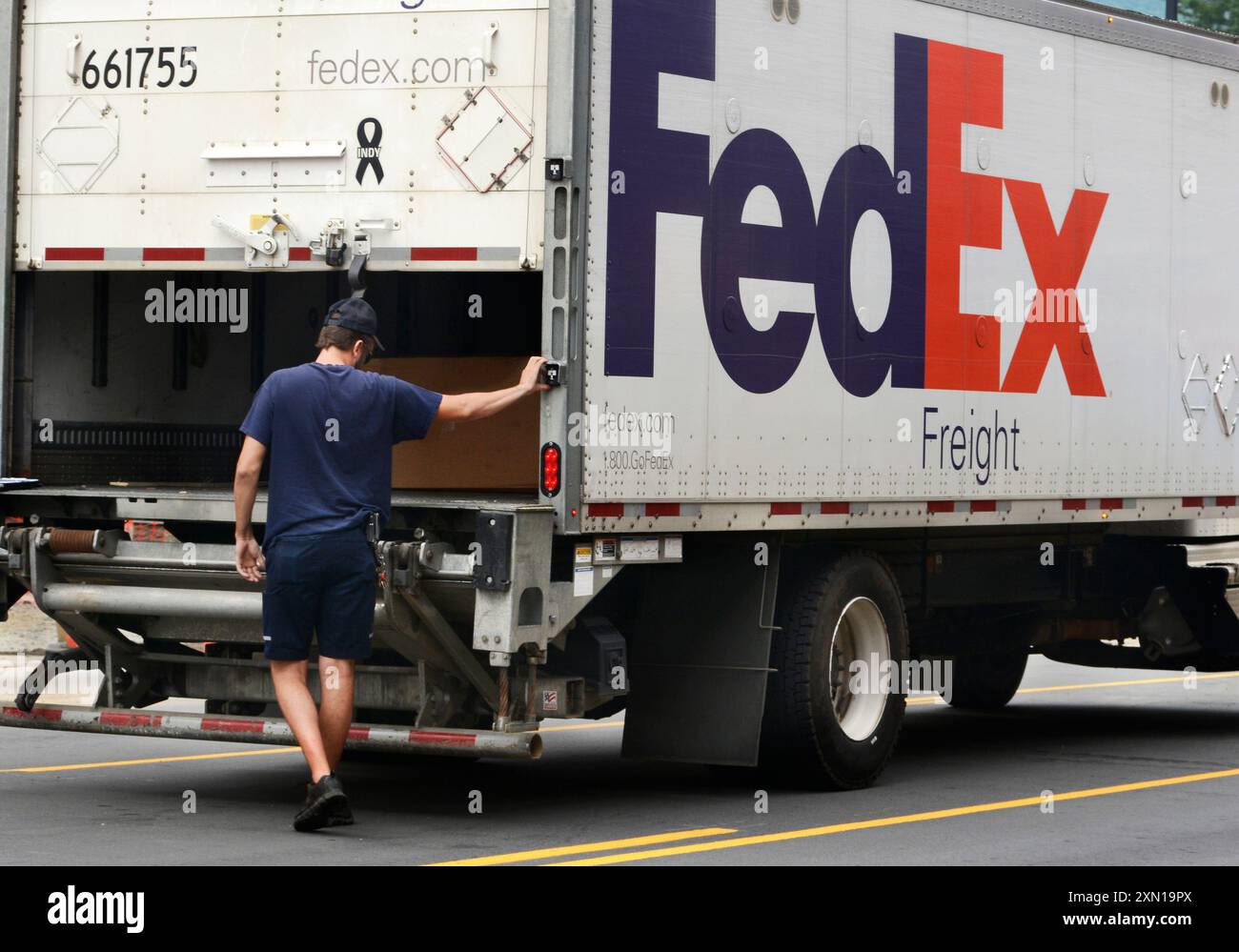 A FedEx, or Federal Express truck and deliveryman deliver merchandise ...