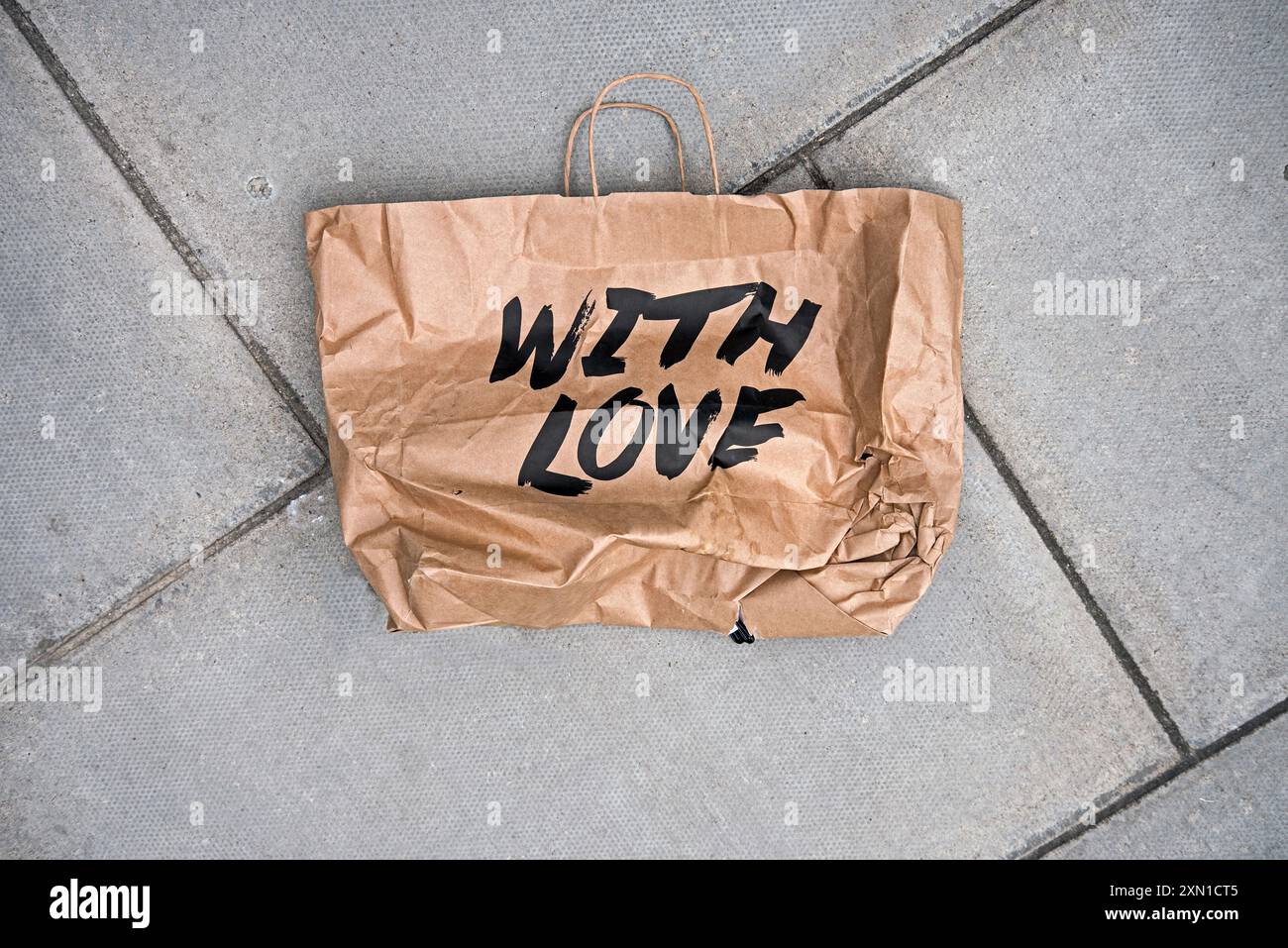 Discarded brown paper carrier bag with the words "With Love" littering ...