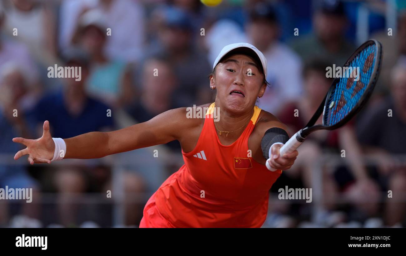 Wang Xiyu of China returns a shot to Iga Swiatek of Poland during their ...