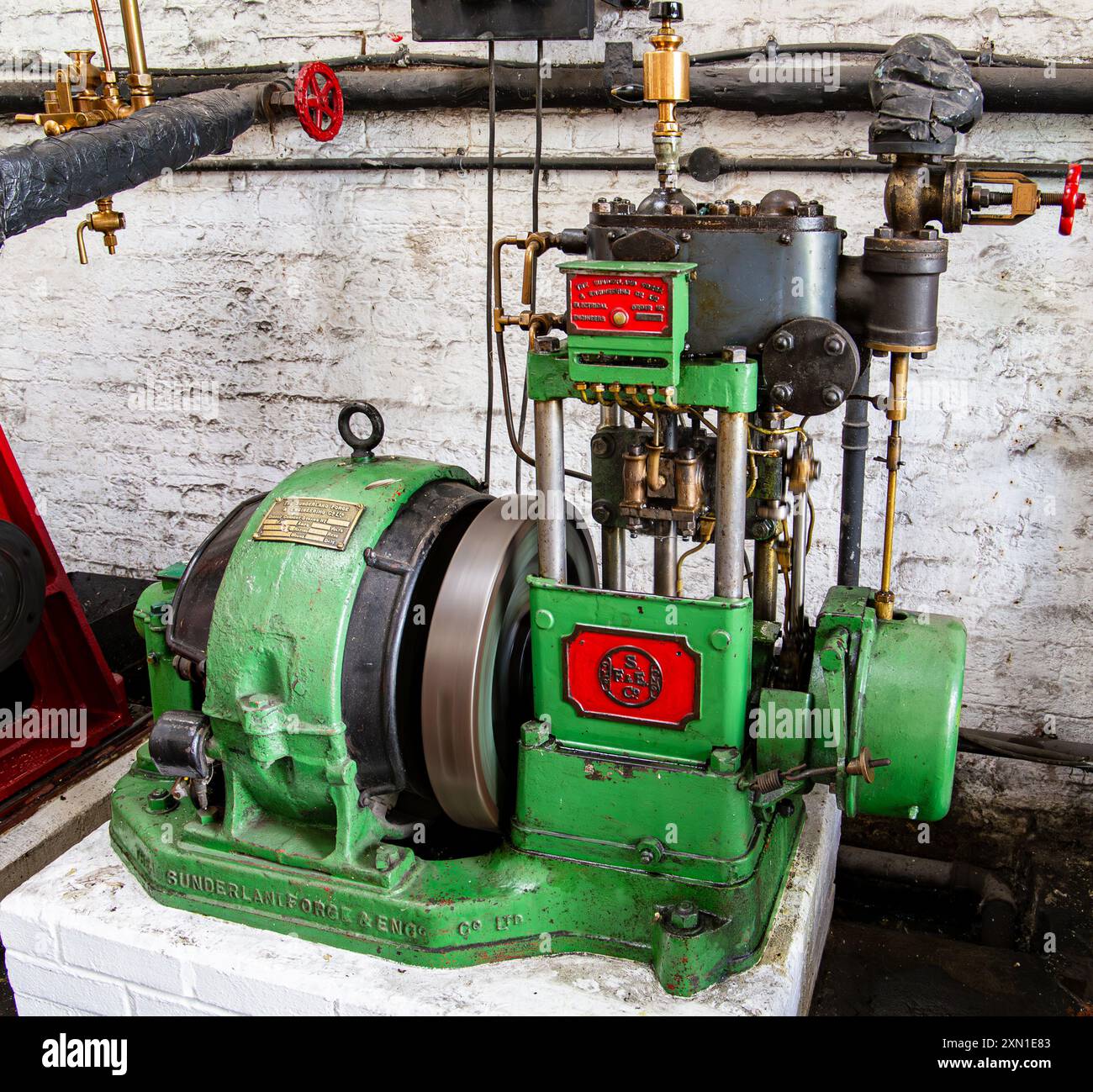 Vintage steam engine running a generator with green and red components ...