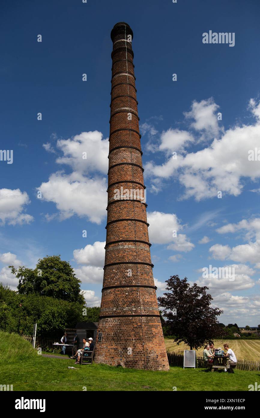 Tall brick chimney at Crofton Beam engines amidst a scenic green field ...