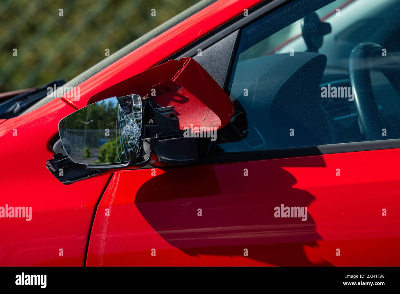Badly damaged side mirror of a small red car Stock Photo - Alamy