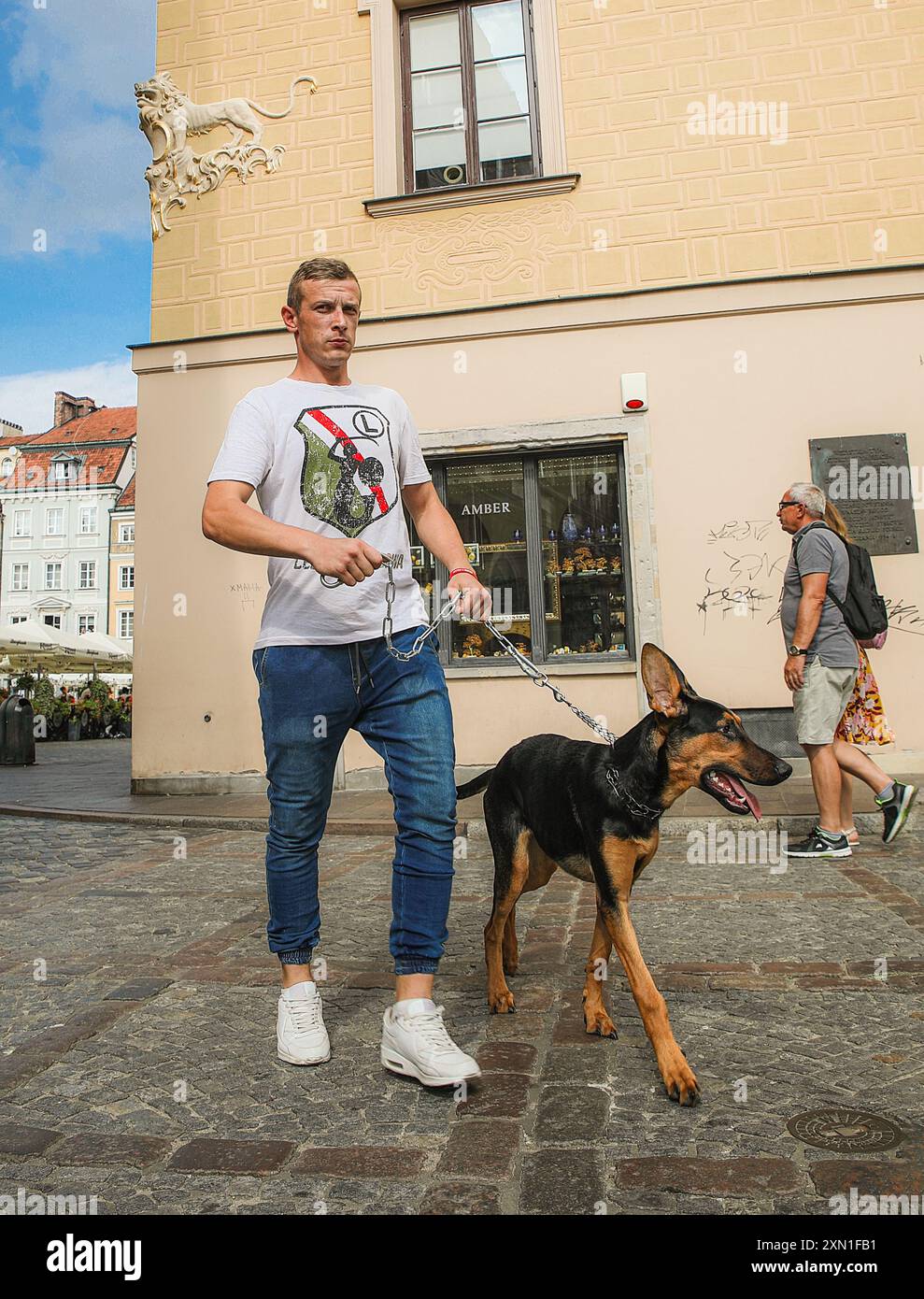 Warsaw, Poland, April 19, 2022: A man walks a sheepdog in the Old Town ...