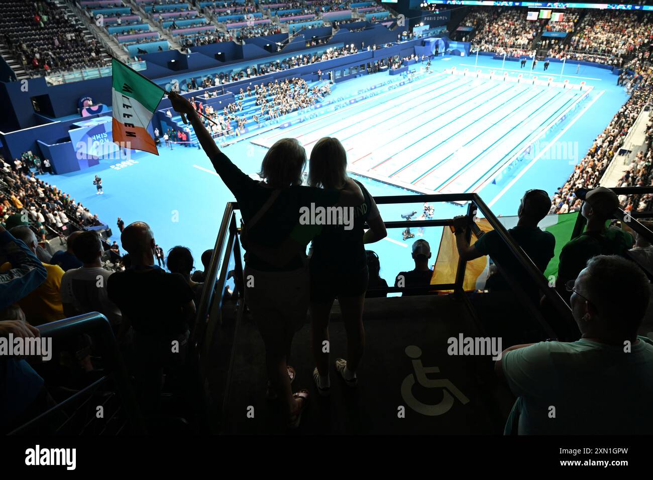 Spectators enjoy watching the swimming races in the Paris Olympics at ...