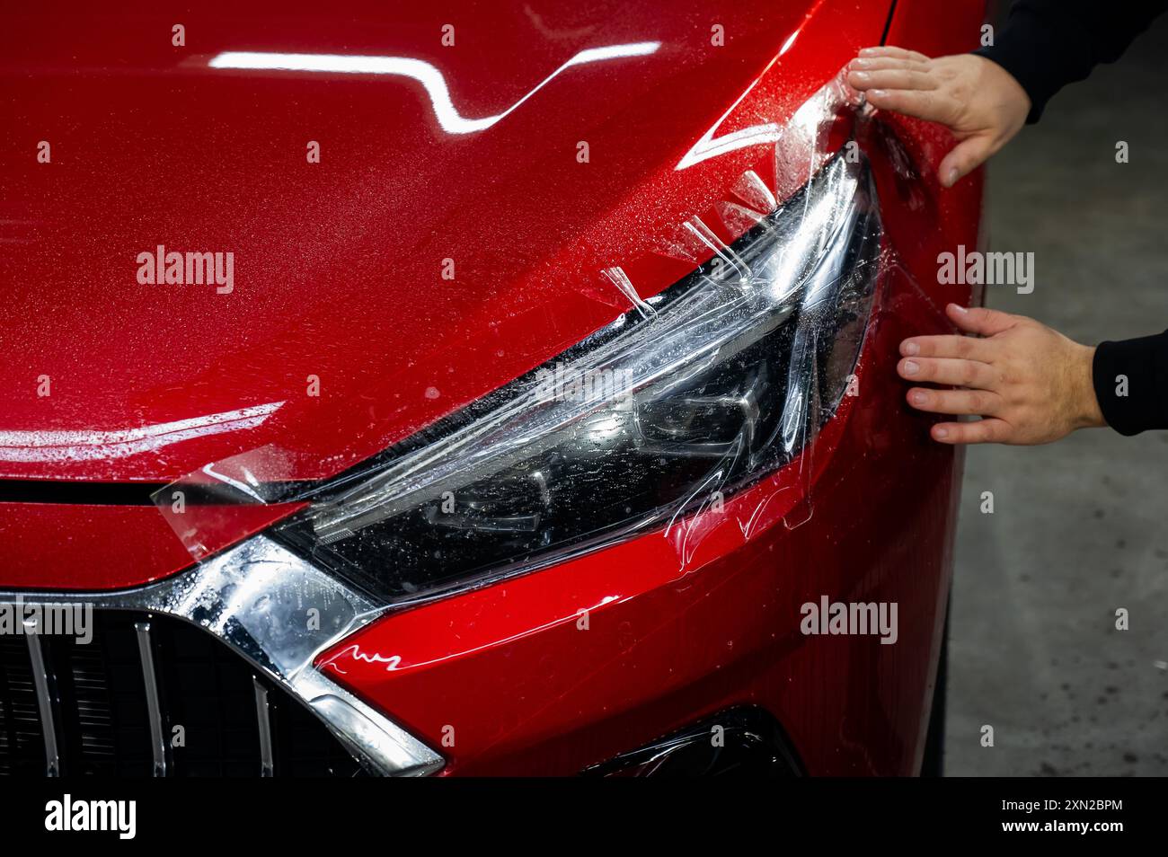 The process of applying protective vinyl film to car headlights in ...