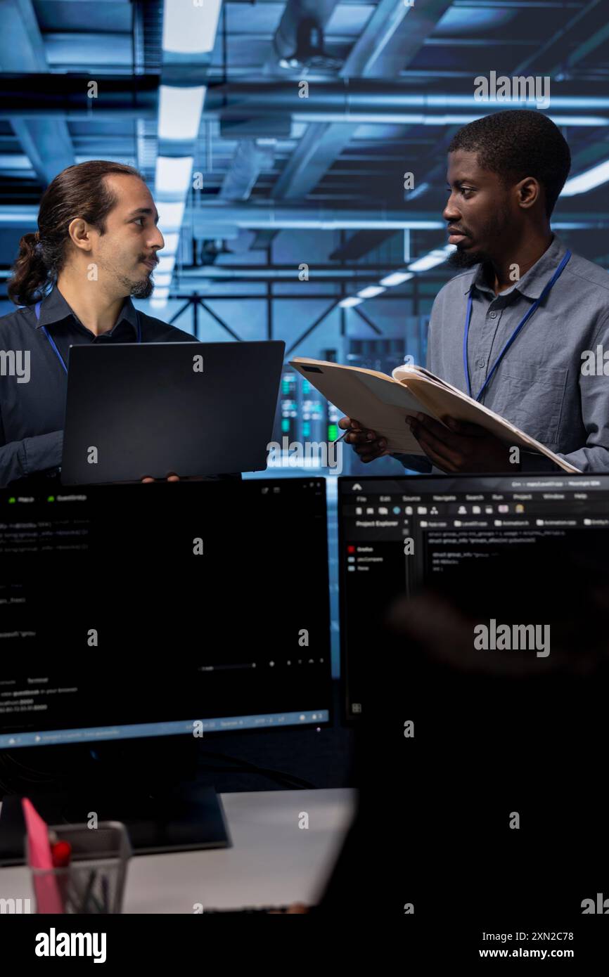 Manager getting feedback from engineer while overseeing data center ...