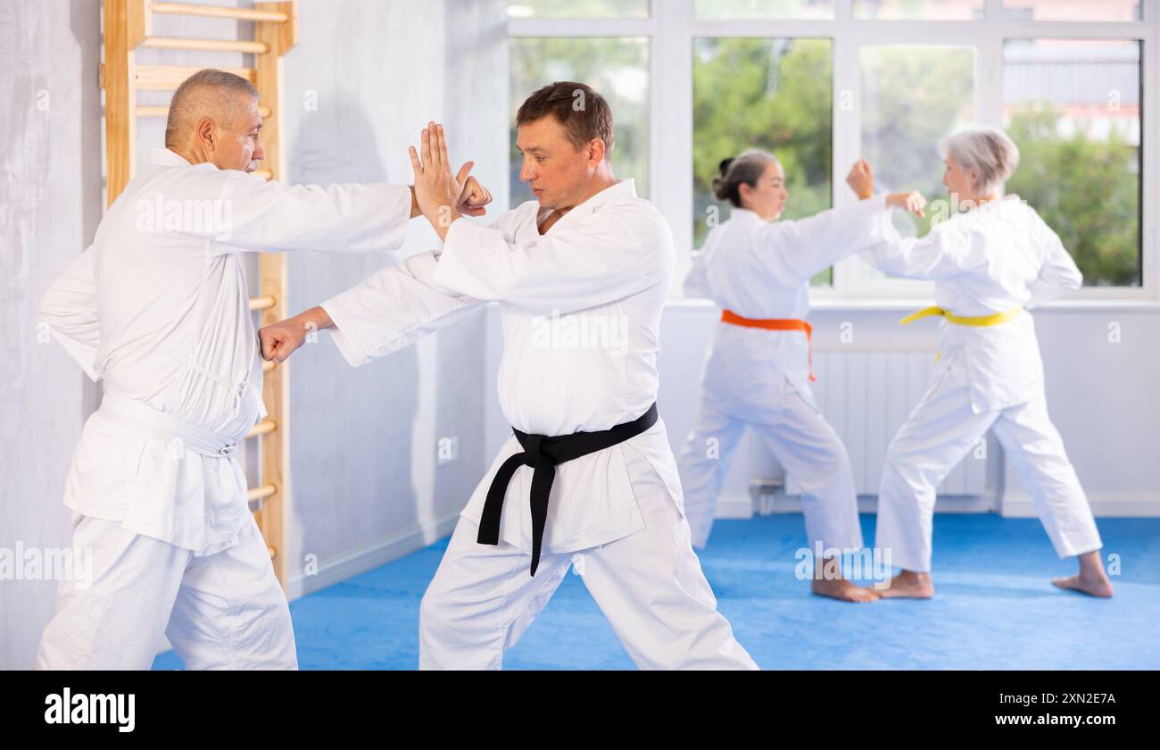 Middle-aged man attendee of karate classes fighting with his opponent ...