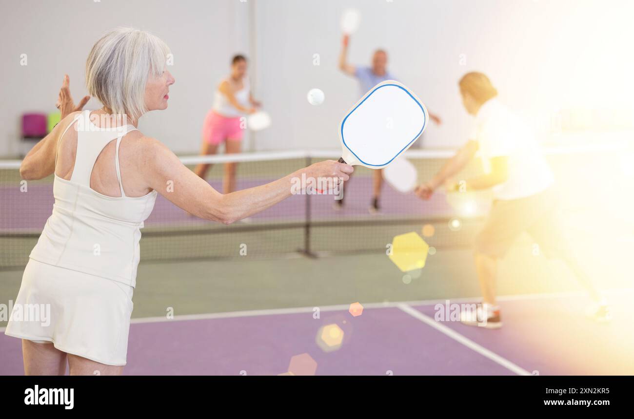 Rear view of woman with white racket playing pickleball tennis Stock ...