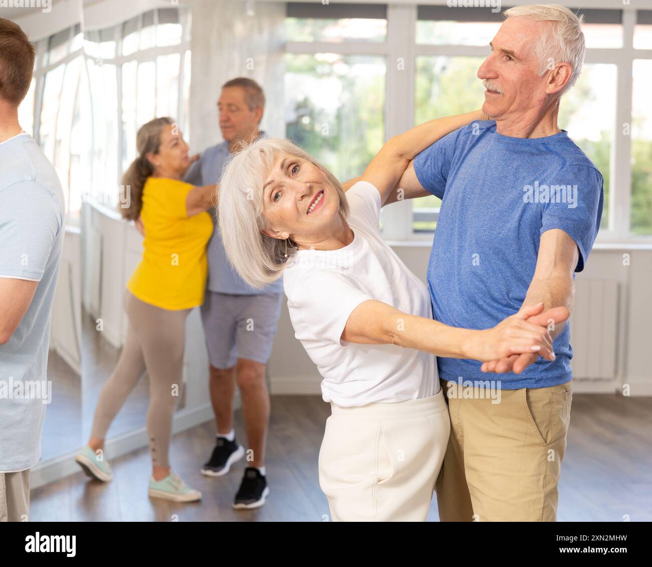 Positive senior woman and man practicing tango dance moves as a couple ...