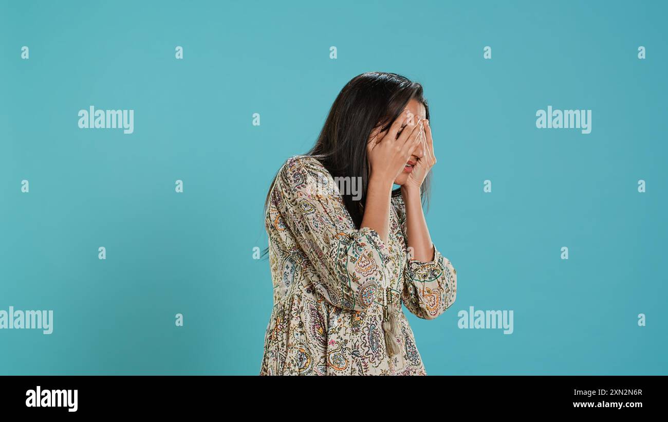 Fearful indian woman covering face with palms, worried about troubling ...
