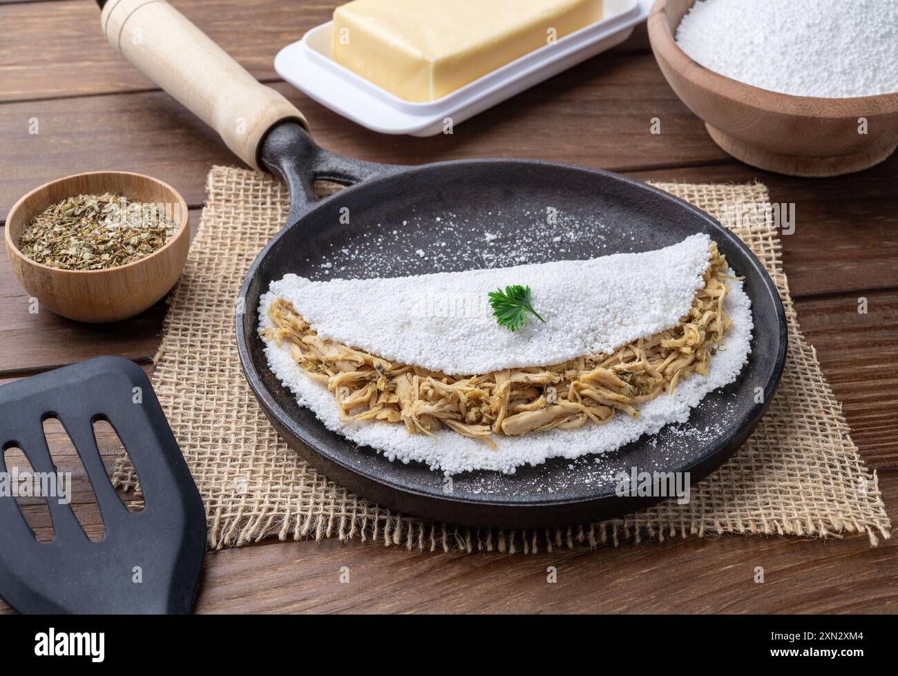 Traditional brazilian chicken stuffed tapioca on a pan with ingredients ...