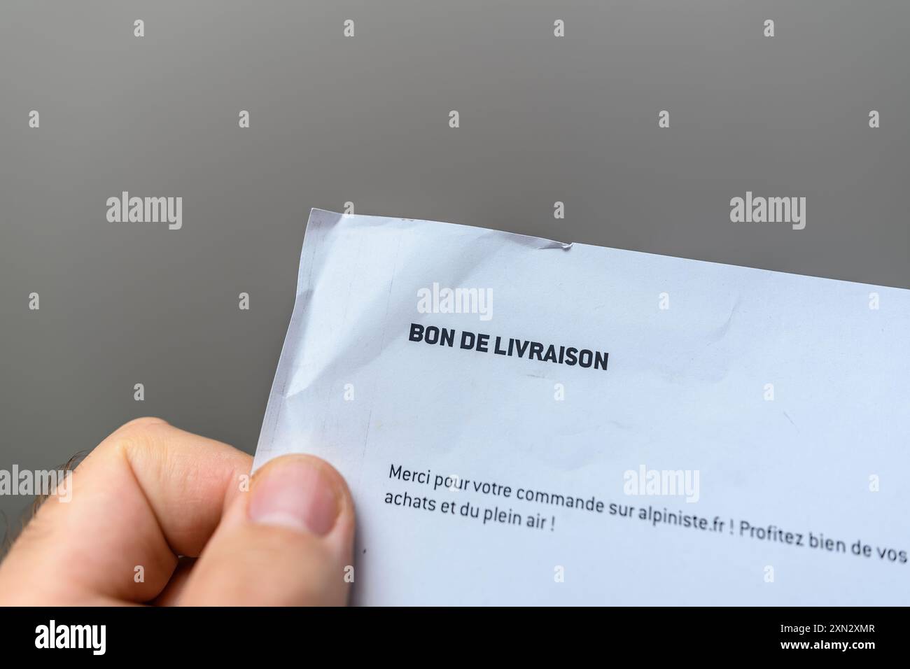 A male hand holding a delivery slip with the text bon de livraison in ...