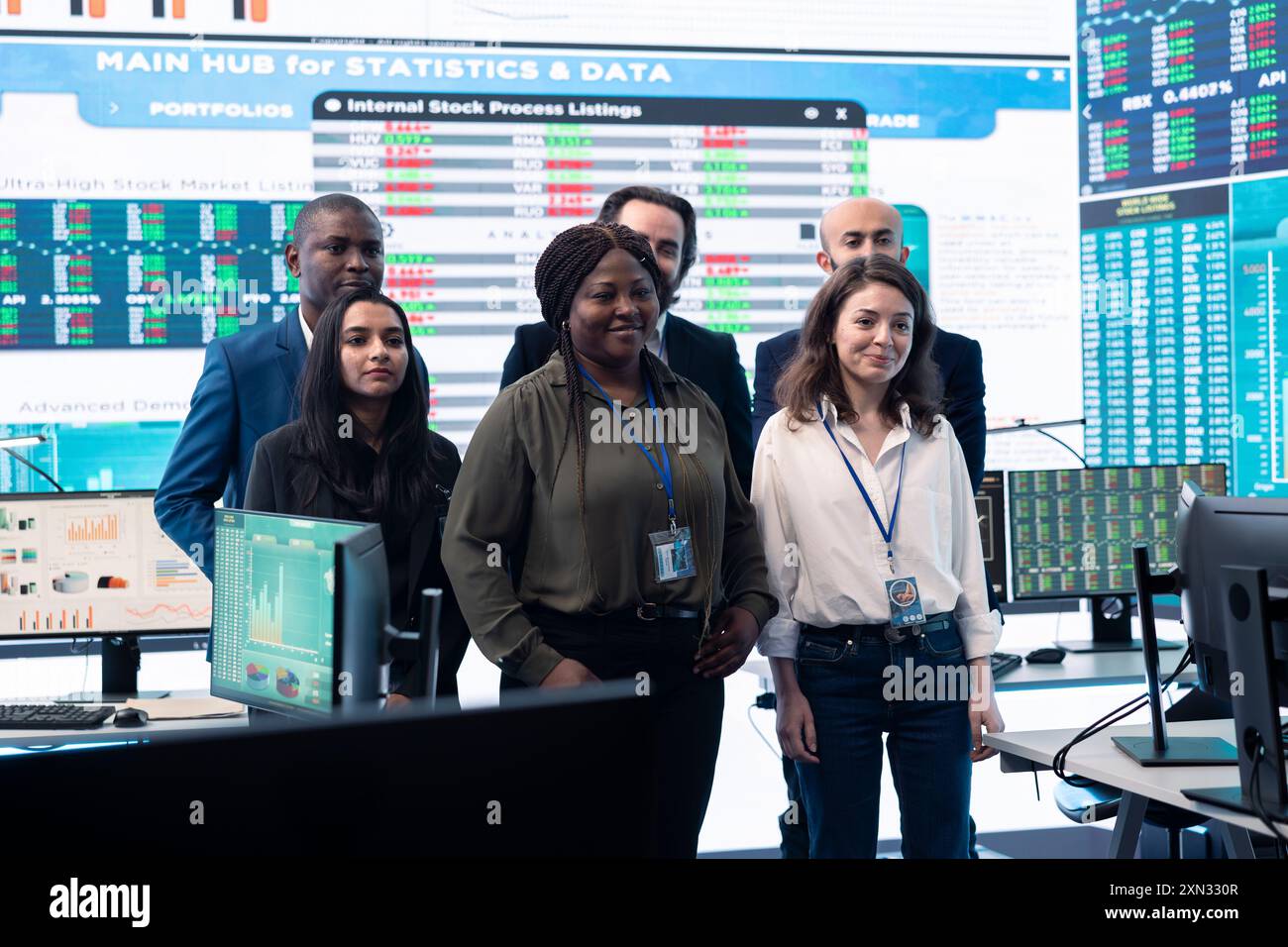 Diverse group of business professionals posing together in monitoring ...