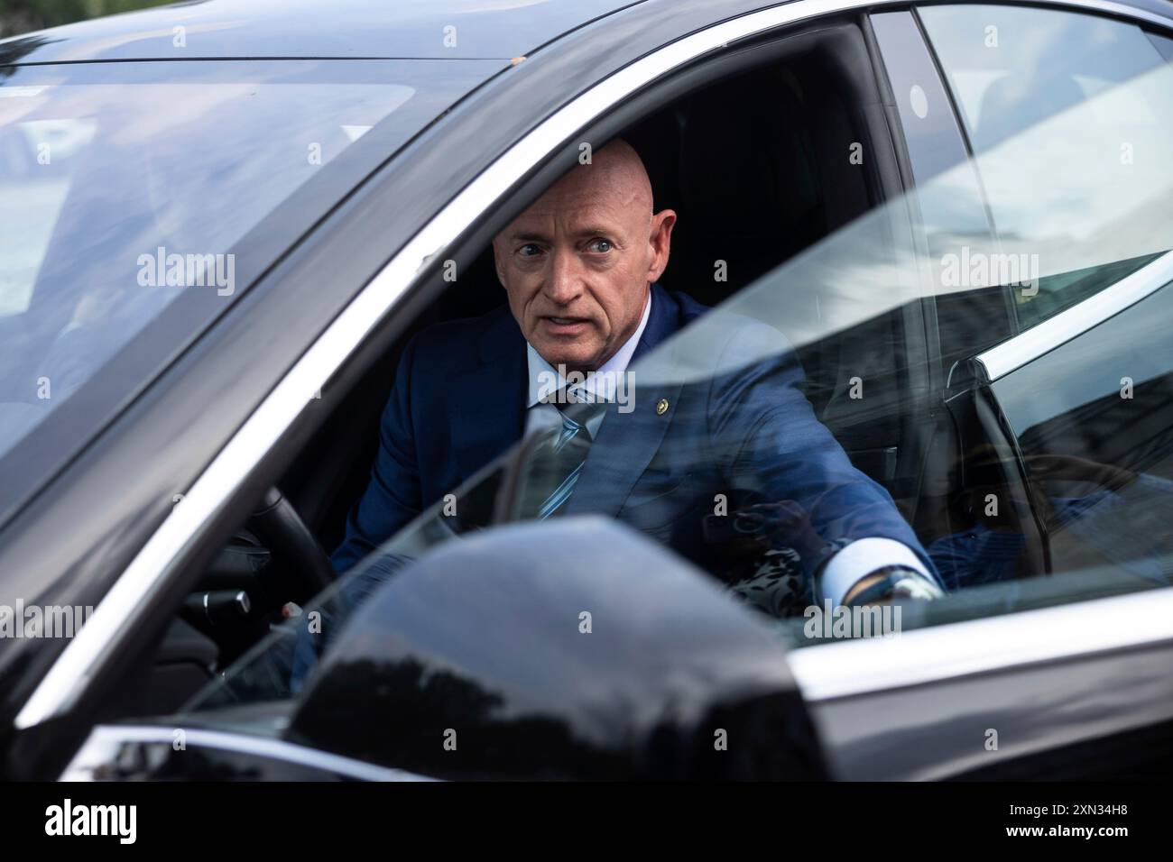 Sen. Mark Kelly (D-Ariz.) speaks with reporters as he boards a Tesla ...