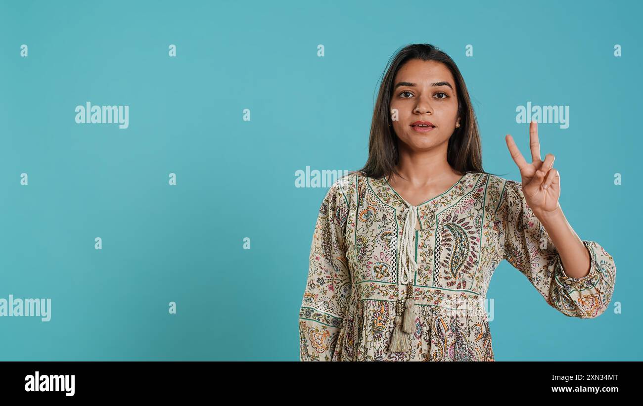 Jolly indian person doing peace victory hand sign gesture, studio ...